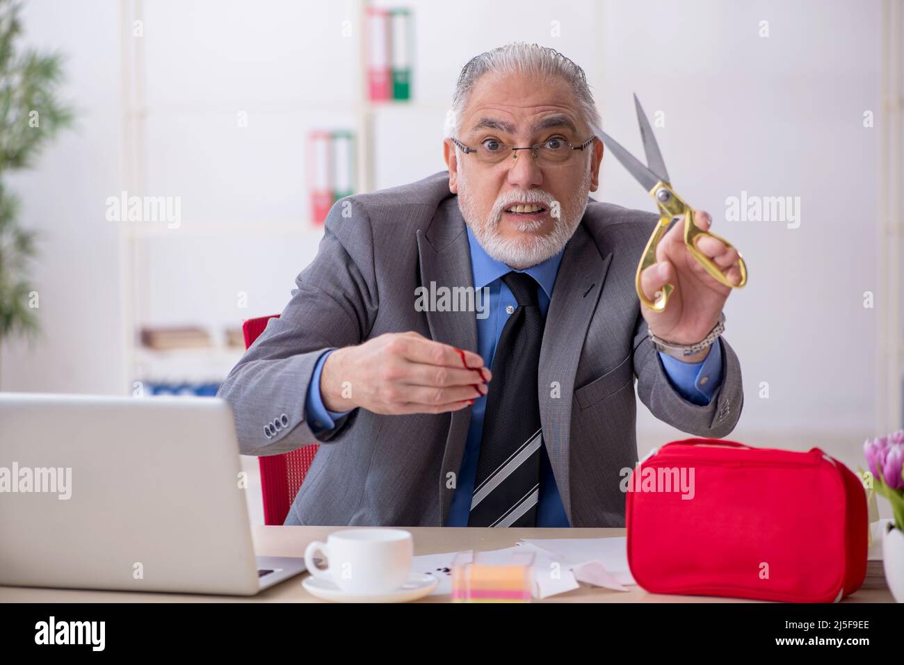 Old businessman employee cutting his hand at workplace Stock Photo - Alamy