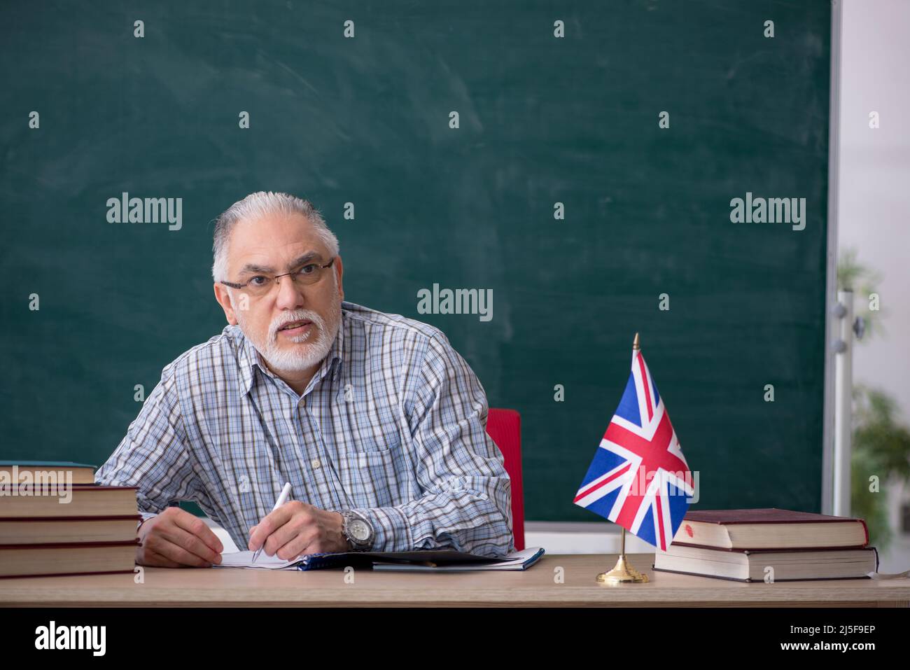 Aged english language teacher in the classroom Stock Photo - Alamy