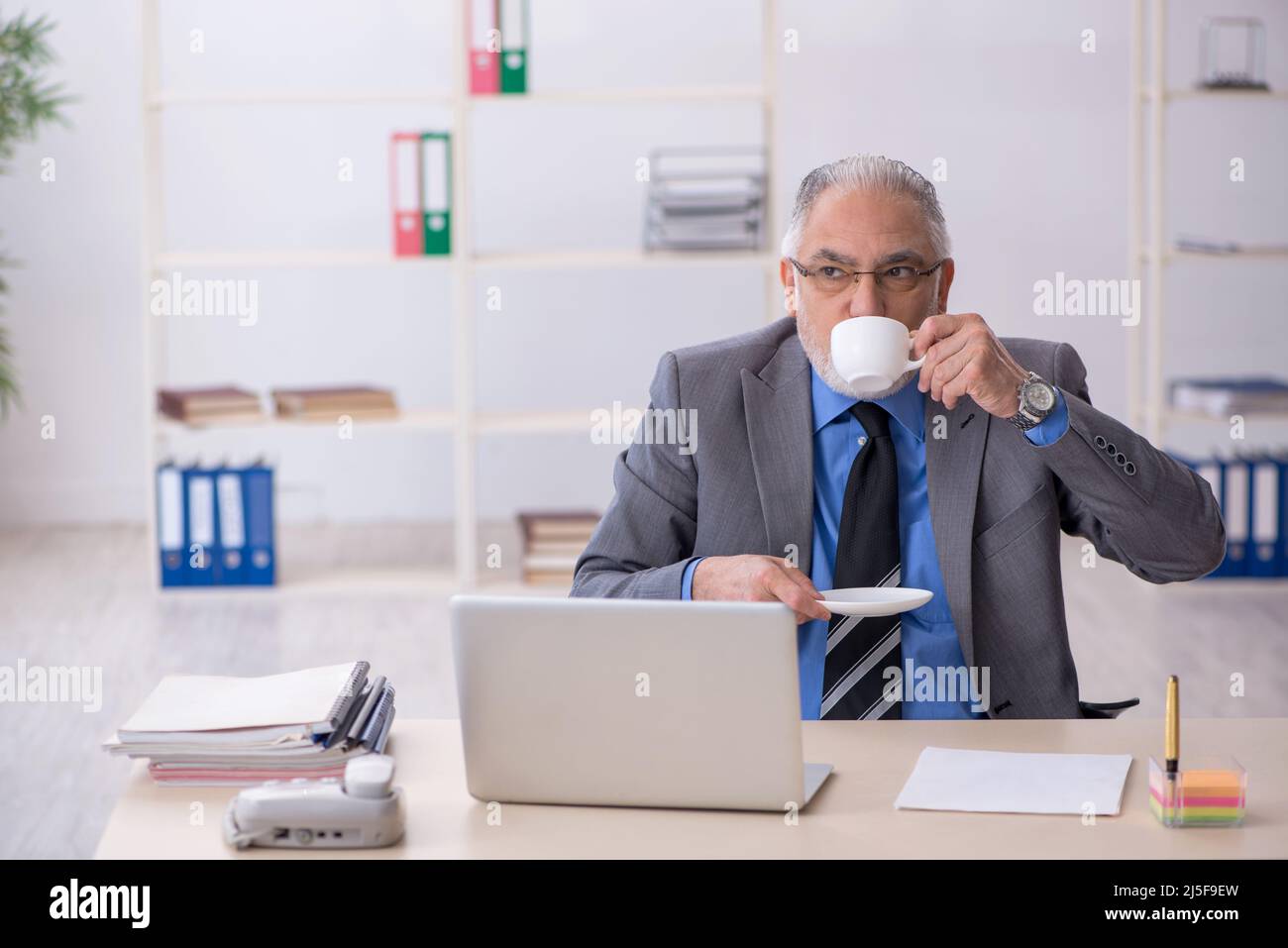 Old businessman employee drinking coffee during break Stock Photo - Alamy