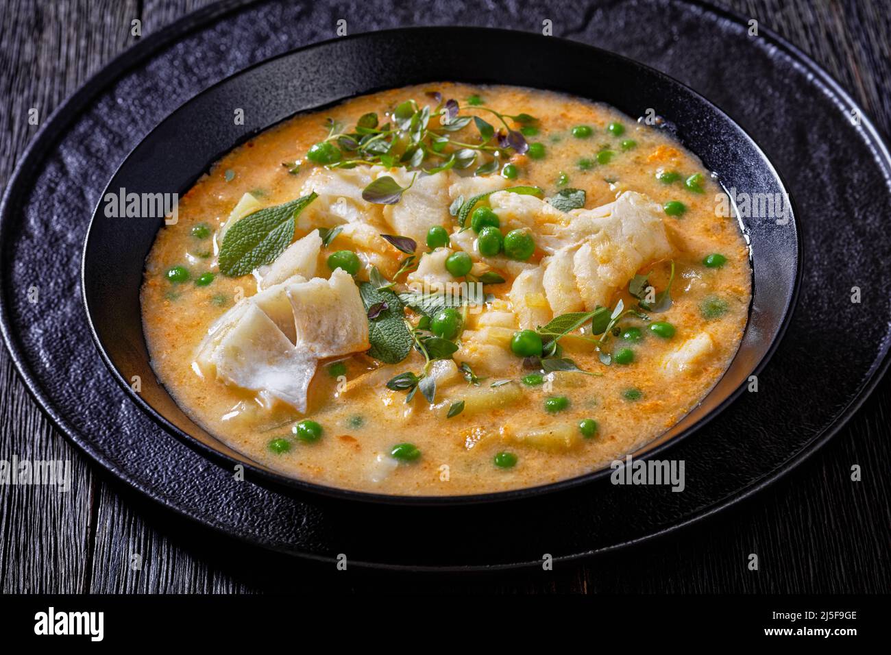 close-up of Creamy fish chowder with cod, green peas, potatoes and ...