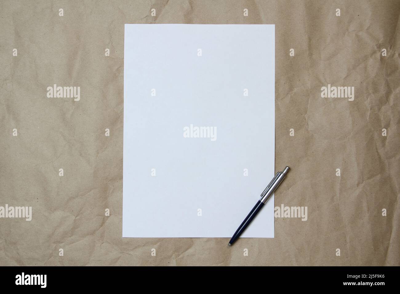 White empty sheet of A4 format with pen on a beige craft paper. Concept ...