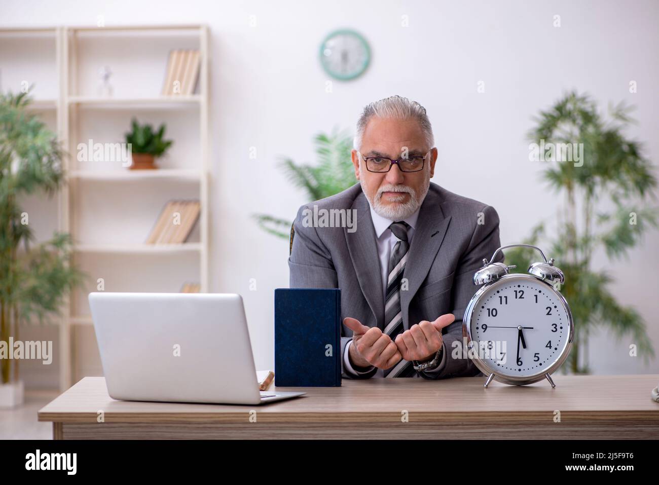 Old businessman employee in time management concept Stock Photo - Alamy