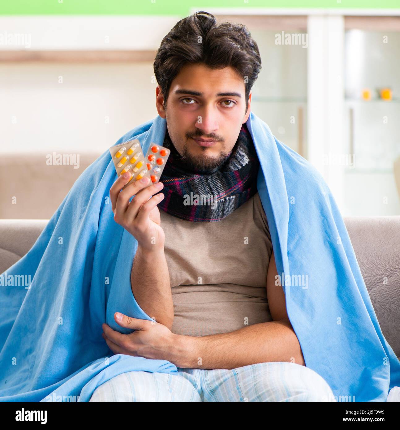 The sick young man suffering from flu at home Stock Photo - Alamy