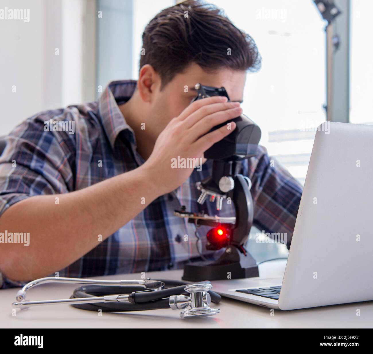 The high precision engineering with man working with microscope Stock ...