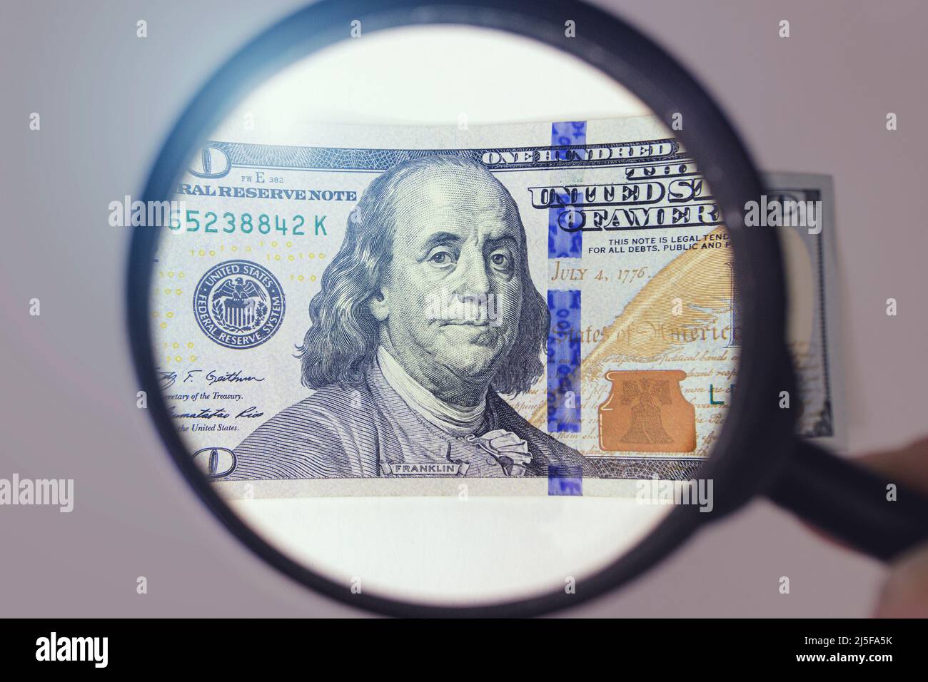 Zoom to money. Investigeting counterfeit money. Magnifying glass on a ...
