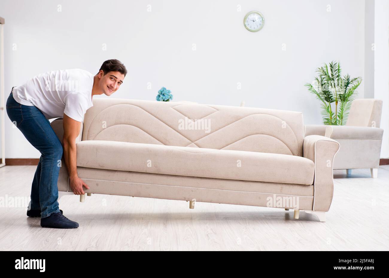 The young man moving furniture at home Stock Photo - Alamy