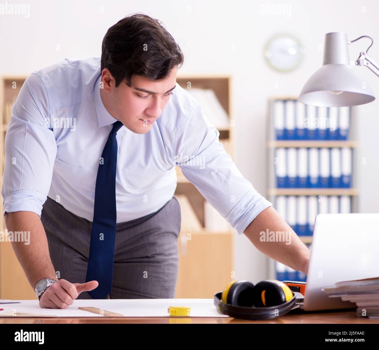 The engineer supervisor working on drawings in the office Stock Photo ...