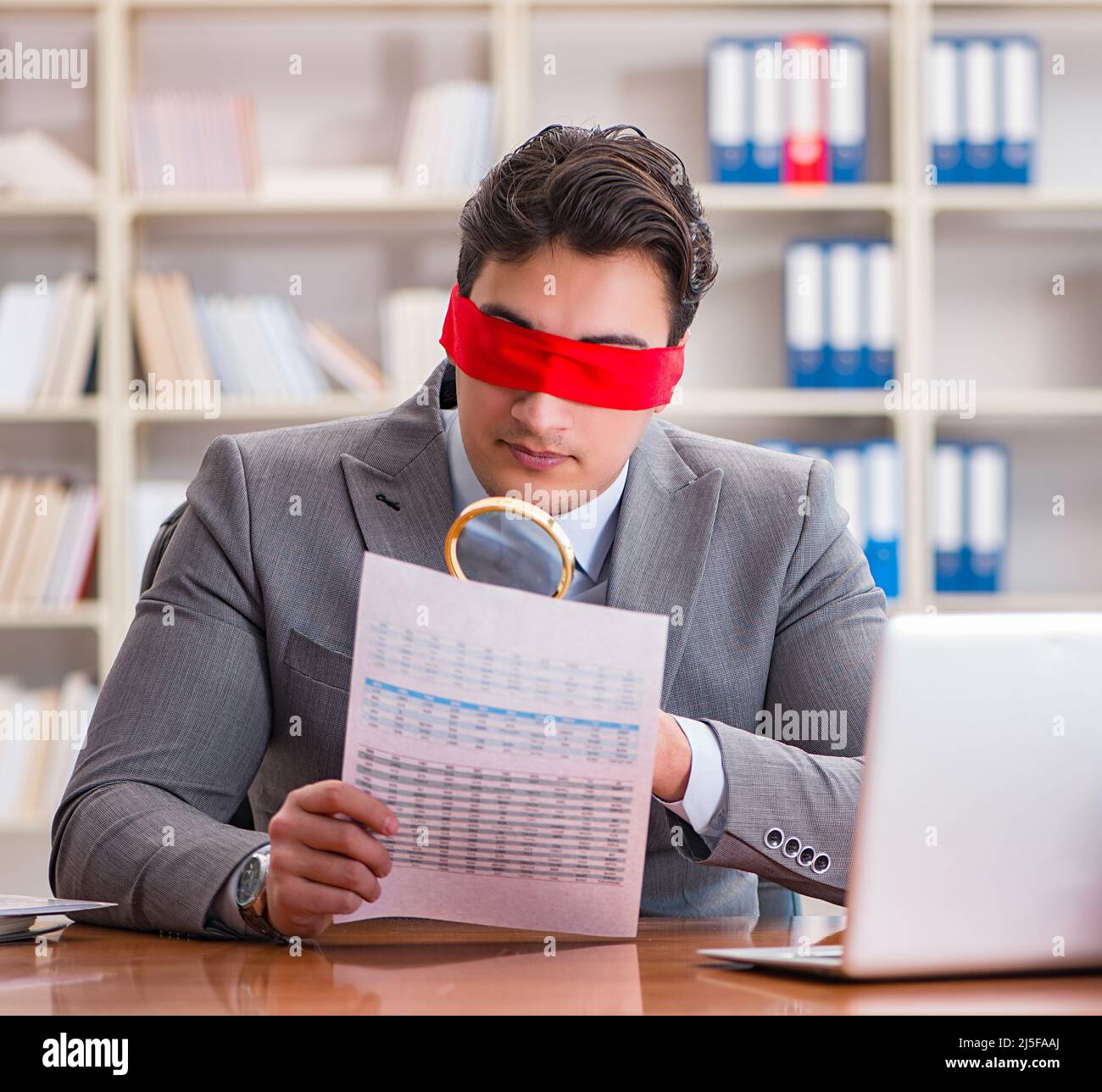 The blindfold businessman sitting at desk in office Stock Photo - Alamy