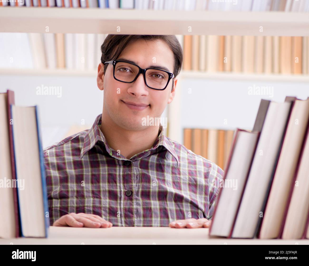 The young student looking for books in college library Stock Photo - Alamy
