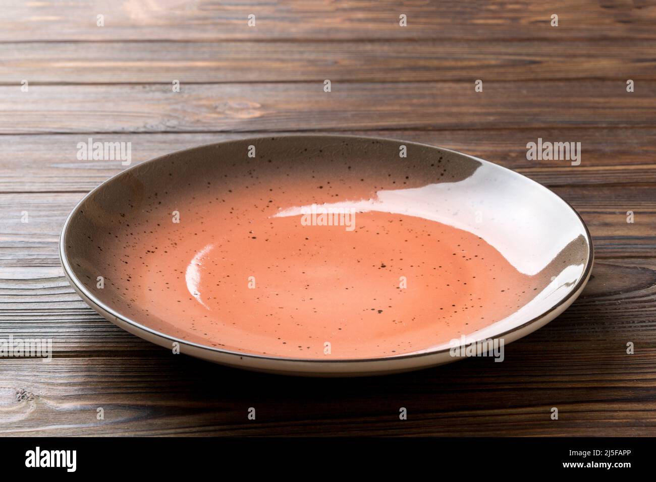 Perspective view of empty red plate on wooden background. Empty space ...