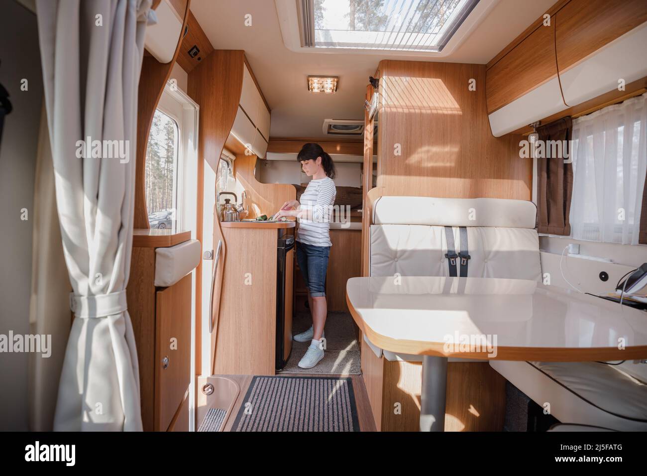 Woman cooking in camper, motorhome RV interior. Family vacation travel ...