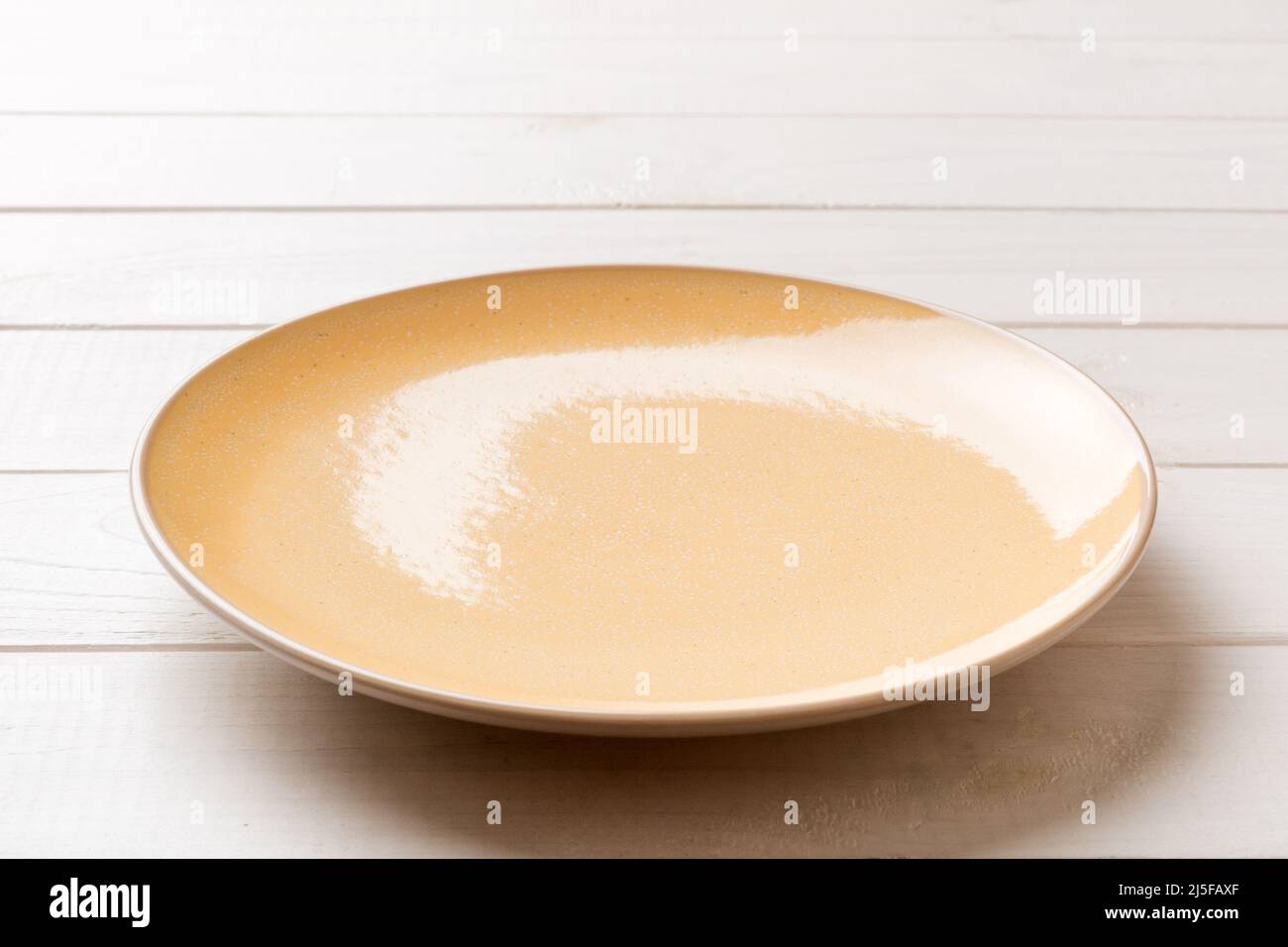 Perspective view of empty orange plate on cement background. Empty ...