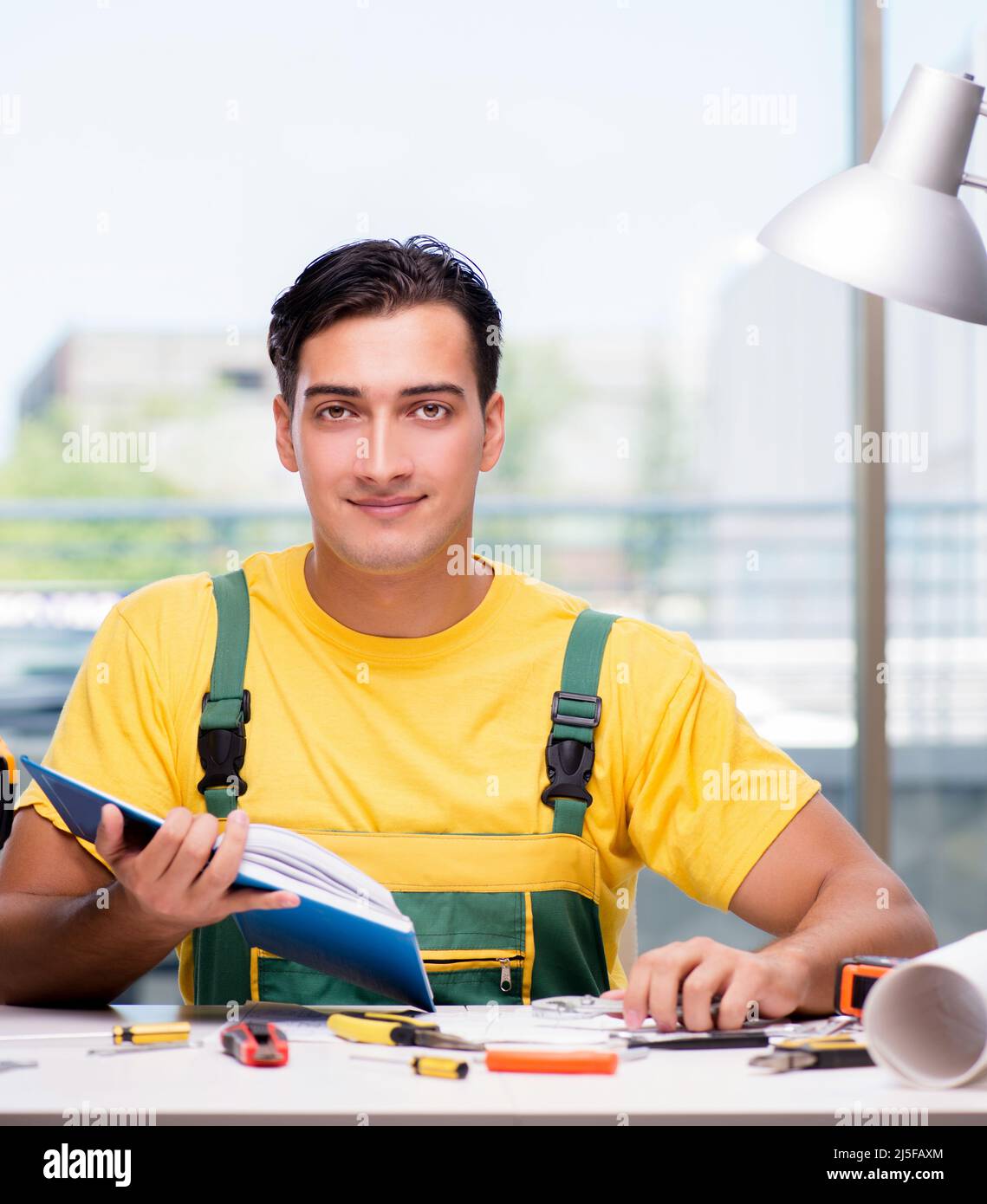The construction worker sitting at the desk Stock Photo - Alamy