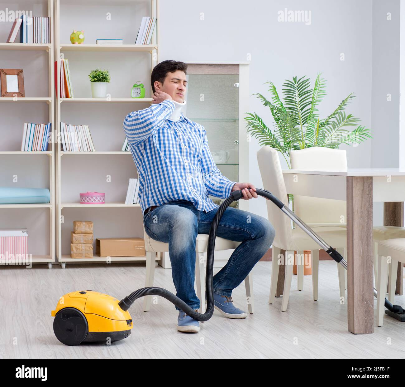 The injured man with neck injury vacuum cleaning house Stock Photo - Alamy