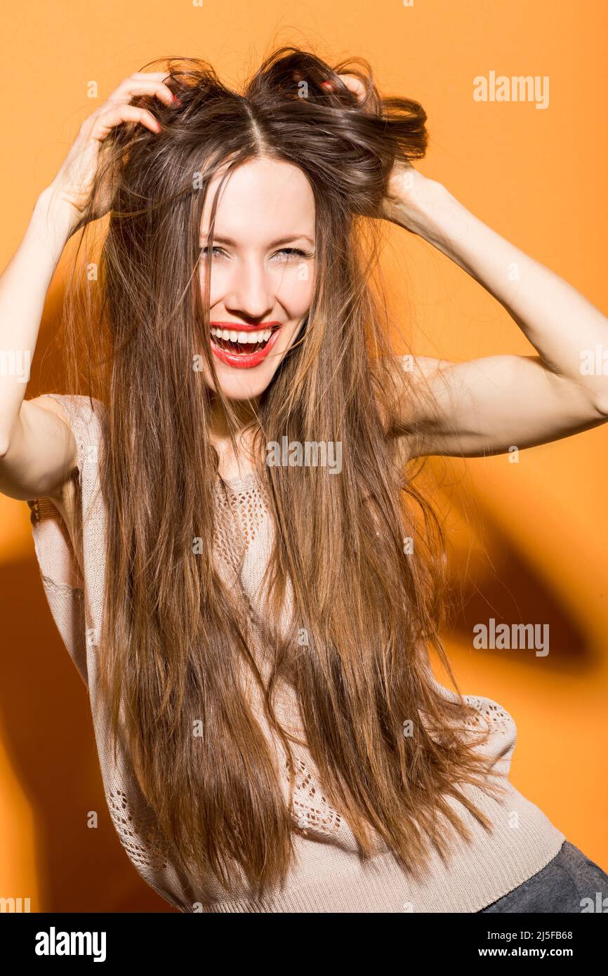 Happy young woman with long hair laughing Stock Photo - Alamy