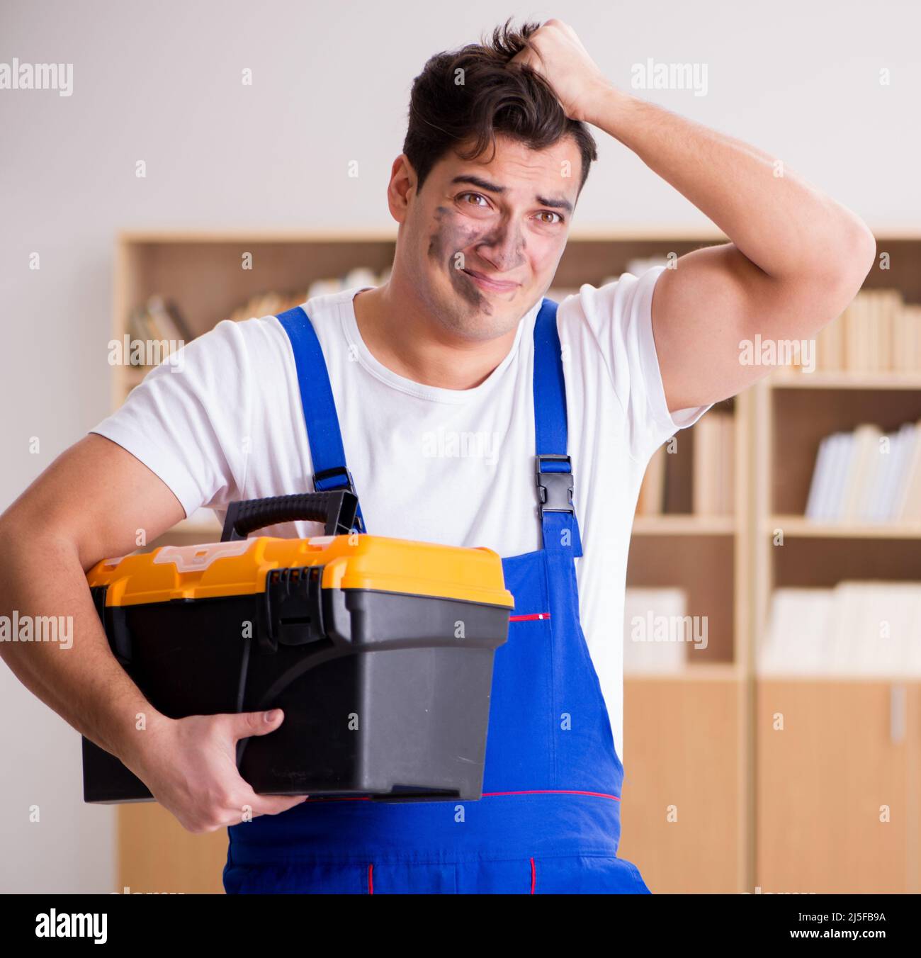 The funny worker with dirty face and toolkit Stock Photo - Alamy