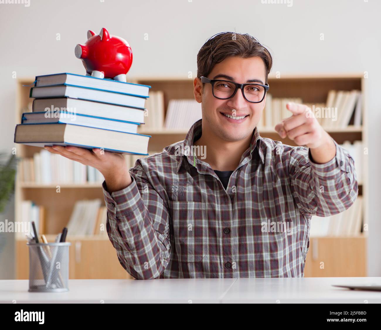 The young student breaking piggy bank to buy textbooks Stock Photo - Alamy