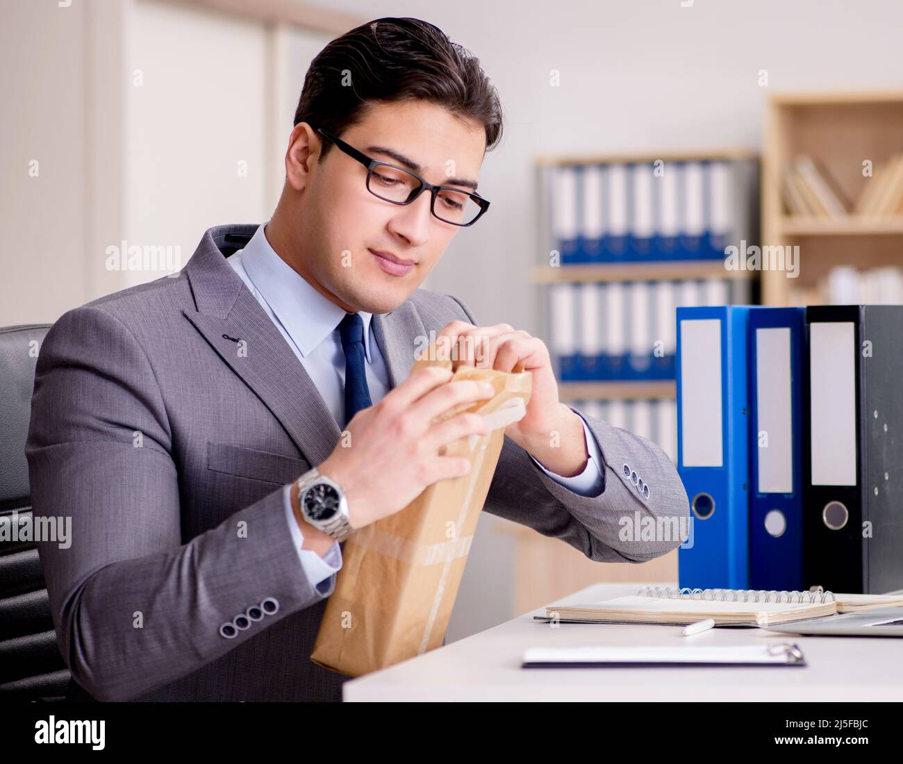 The businessman receiving parcel in office Stock Photo - Alamy