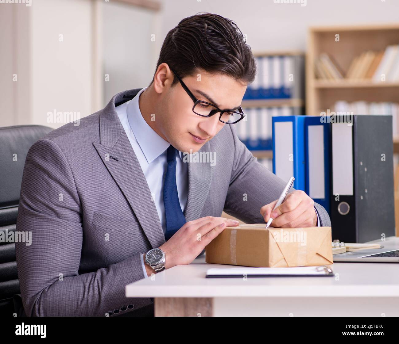 The businessman receiving parcel in the office Stock Photo - Alamy