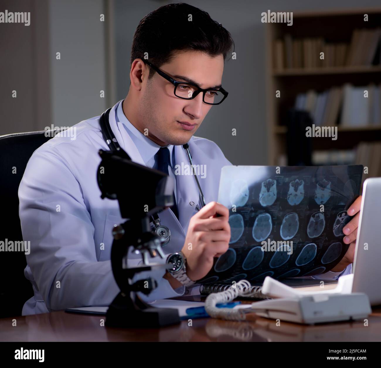 The young doctor working late in the office Stock Photo - Alamy