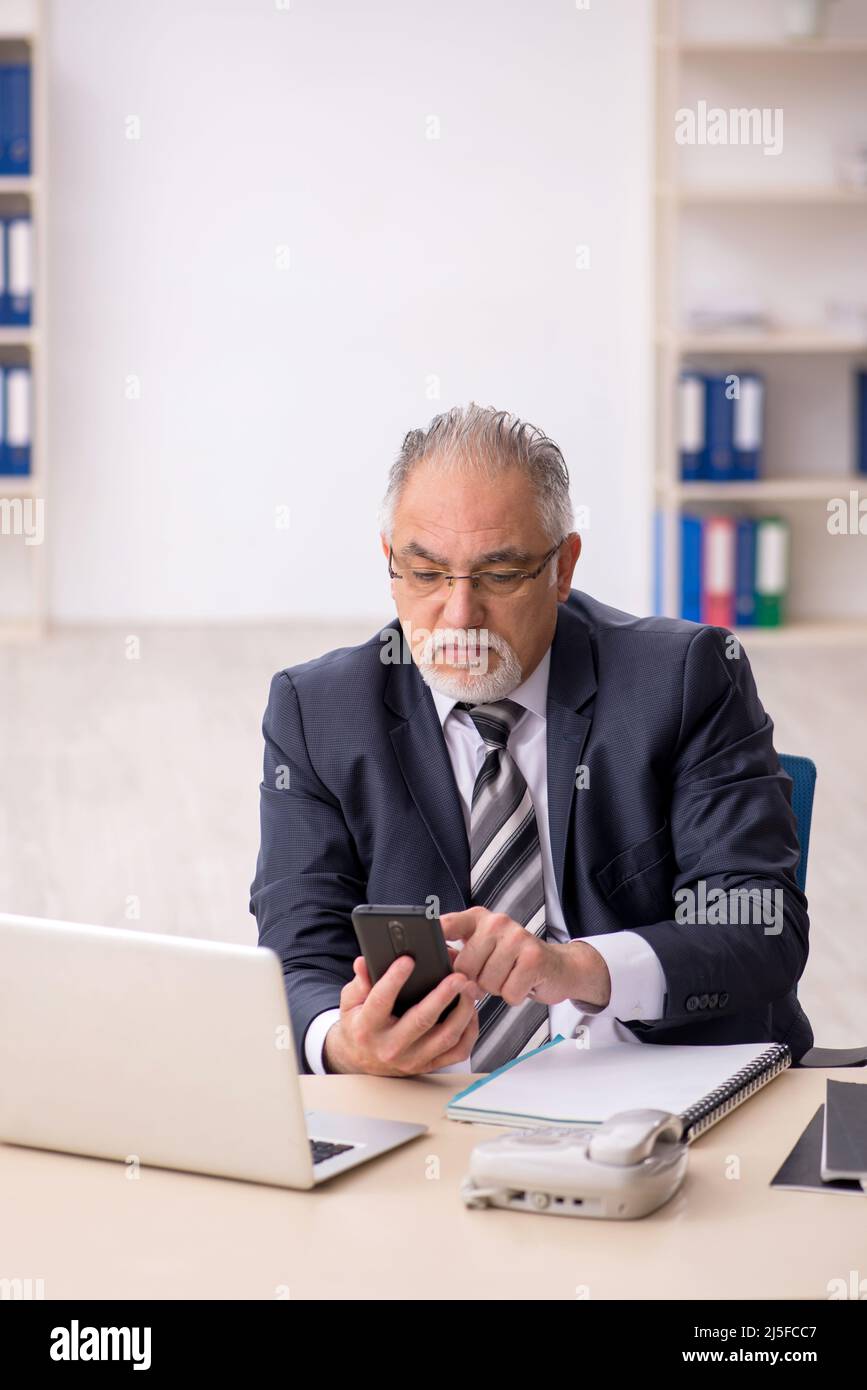 Old businessman employee working in the office Stock Photo - Alamy