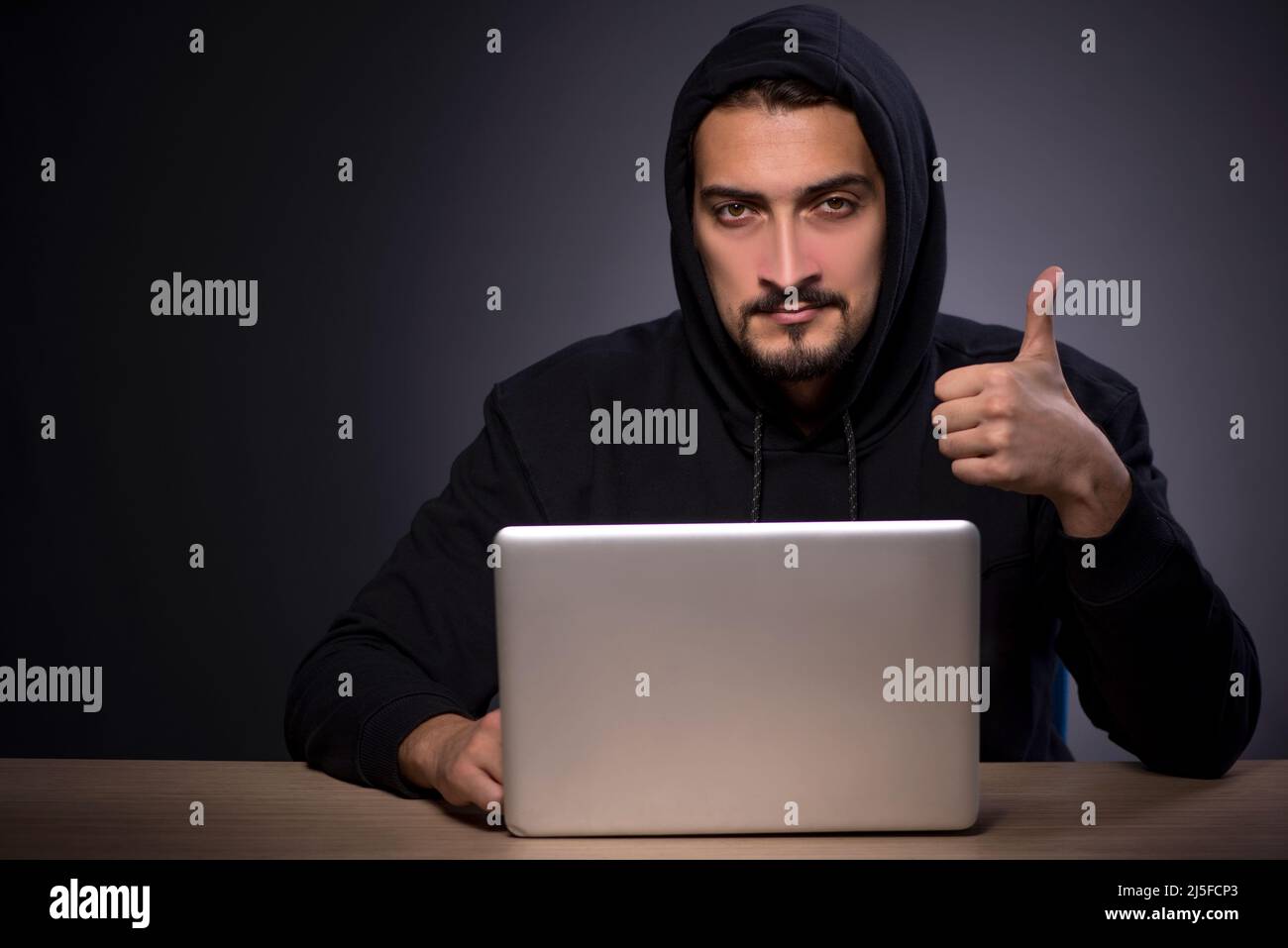 Young hacker on grey background Stock Photo - Alamy