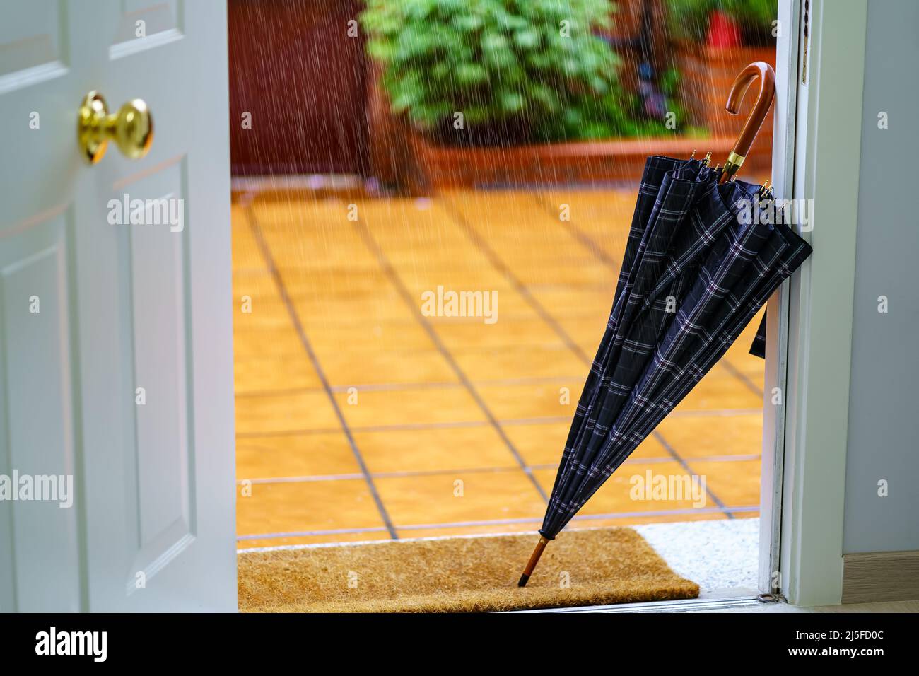 Umbrella at the entrance gives a house and very rainy day outside the ...