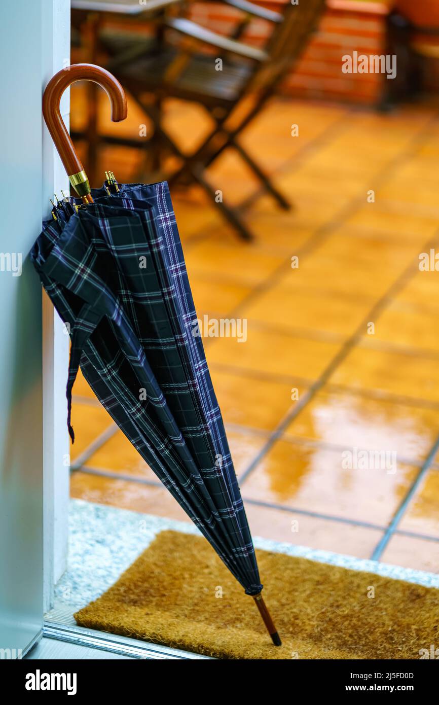 Umbrella at the door of a house and garden in the background on a very ...