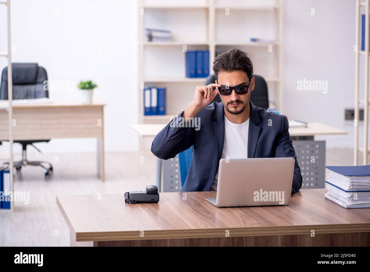 Young male employee working in the office Stock Photo - Alamy