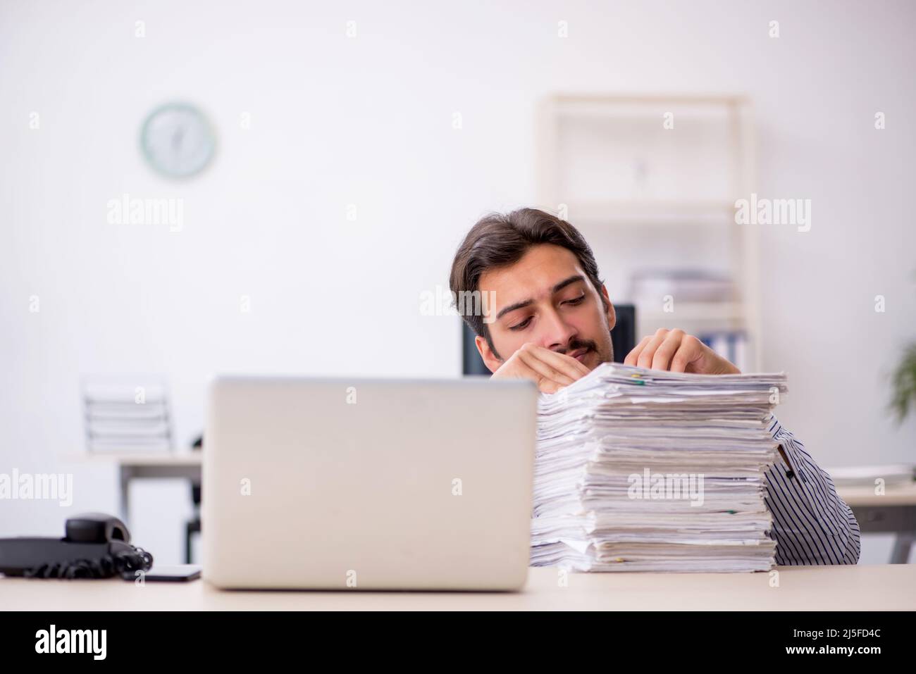 Young businessman employee and too much work in the office Stock Photo ...