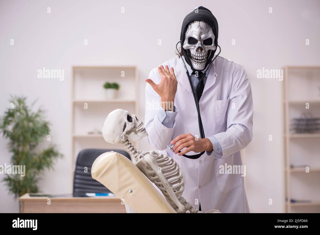 Devil doctor examining skeleton patient in the clinic Stock Photo - Alamy