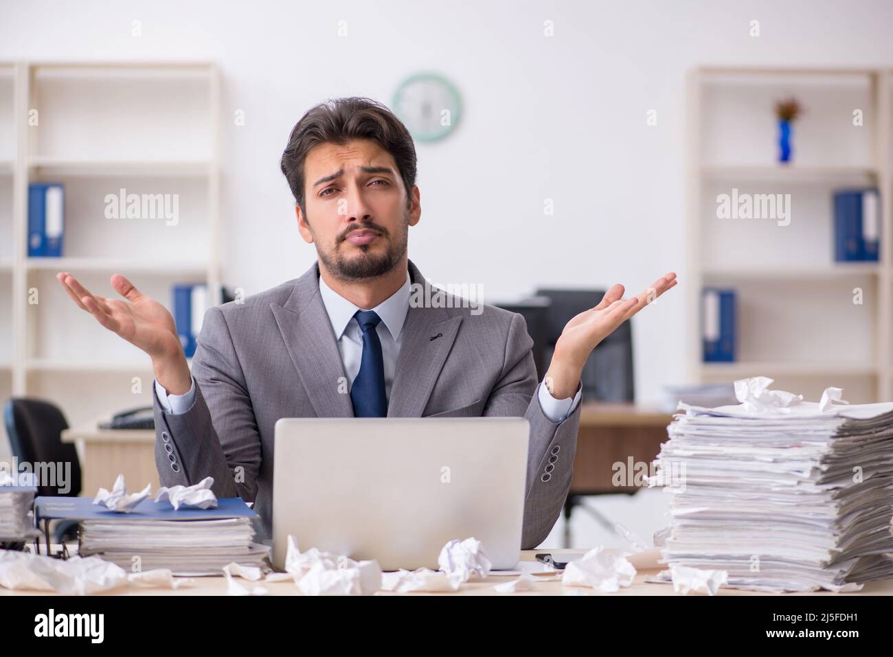 Young employee and too much work in the office Stock Photo - Alamy