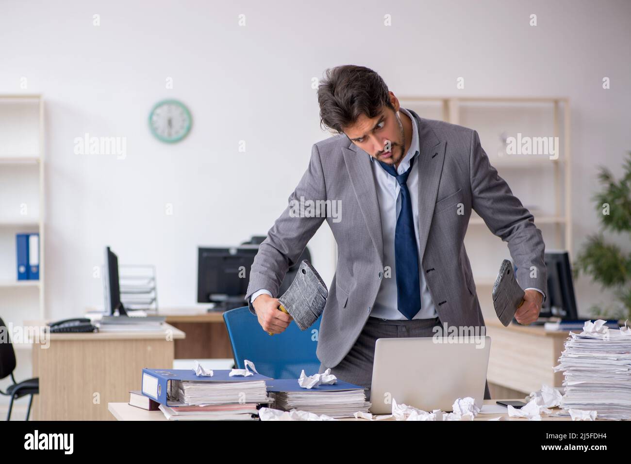 Young employee and too much work in the office Stock Photo - Alamy