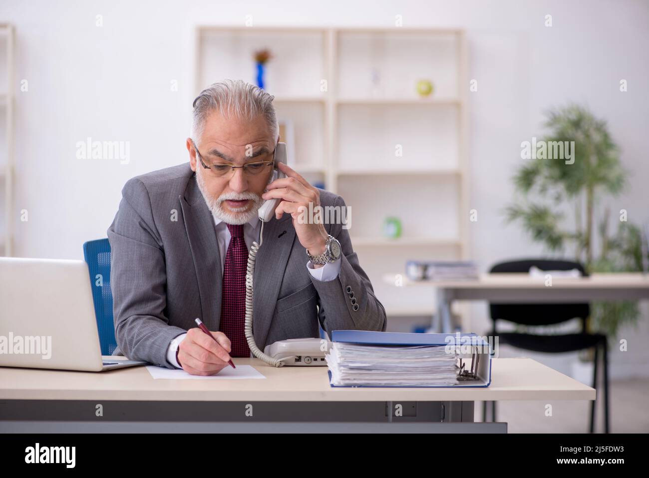 Old employee working in the office Stock Photo - Alamy