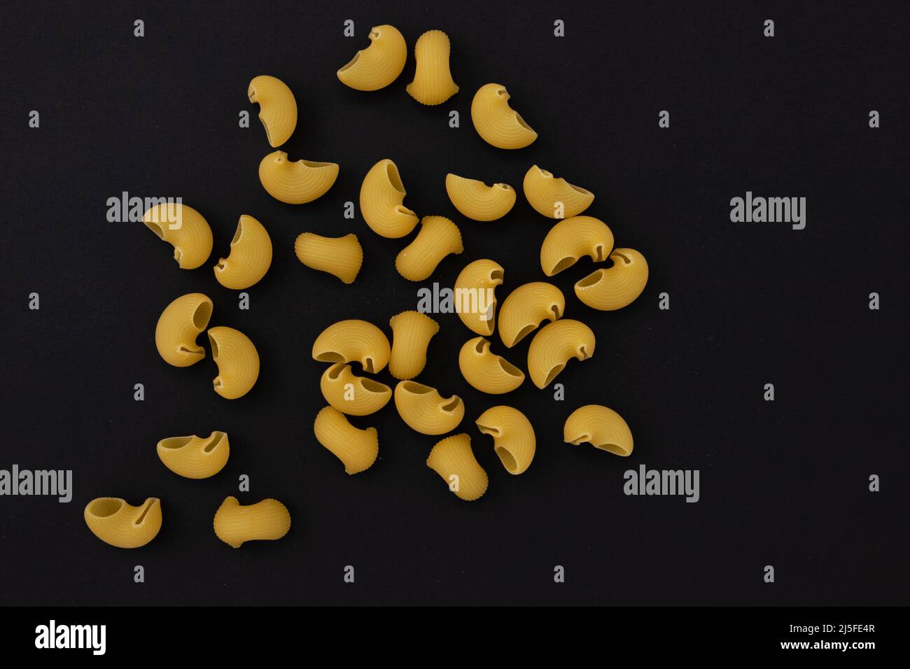 heap of pipe rigate pasta with empty space for text isolated on black ...