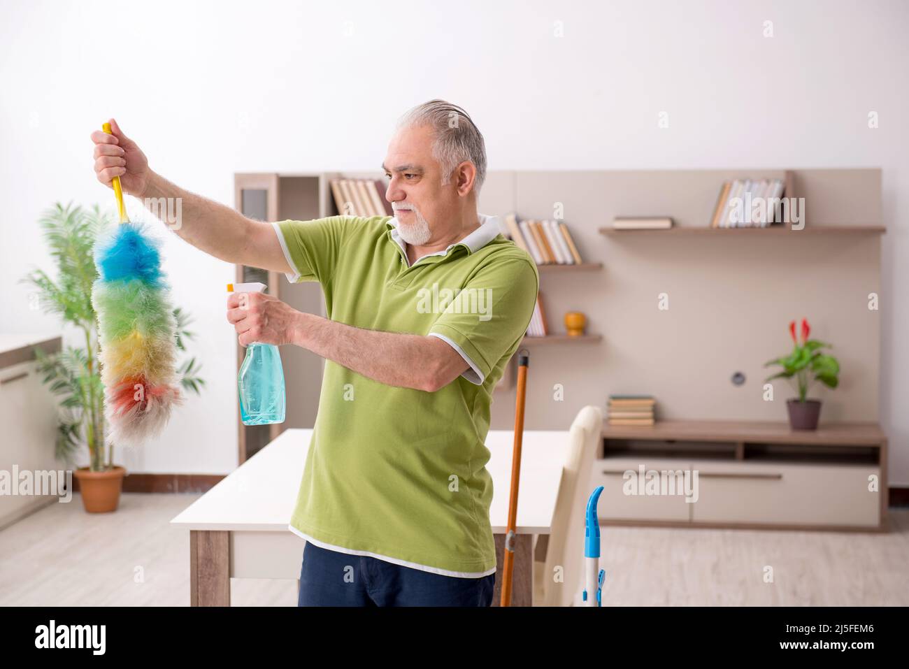 Aged man cleaning the house Stock Photo - Alamy