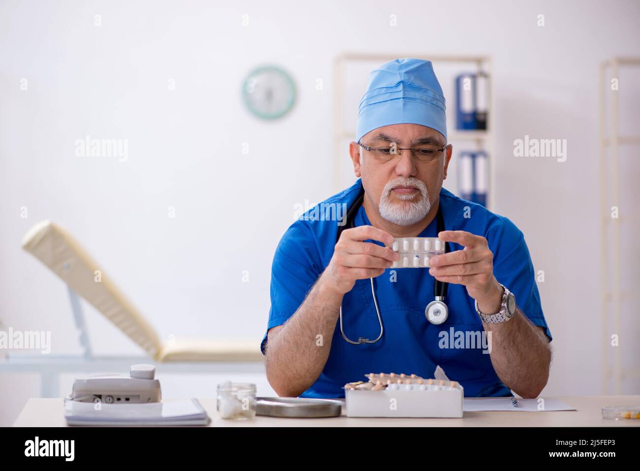 Old doctor working in the clinic Stock Photo - Alamy
