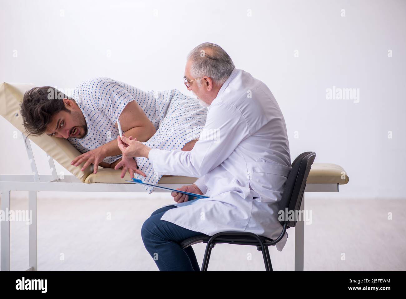 Old doctor psychiatrist examining young male patient Stock Photo - Alamy