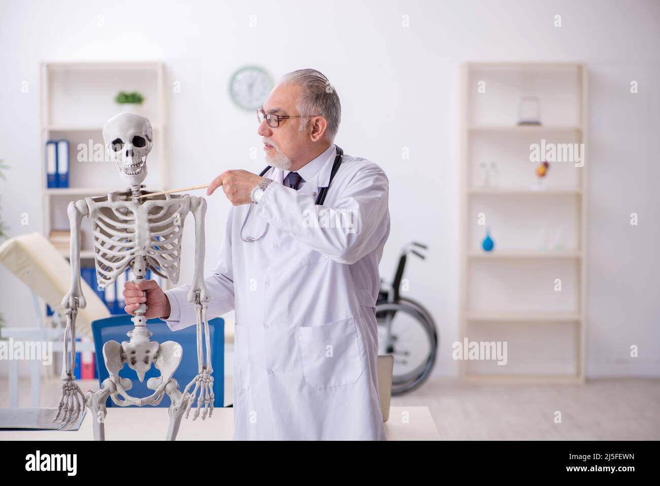 Old doctor demonstrating human skeleton Stock Photo - Alamy