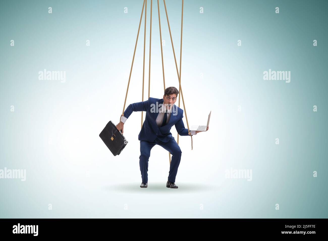 Businessman puppet being manipulated by the ropes Stock Photo - Alamy