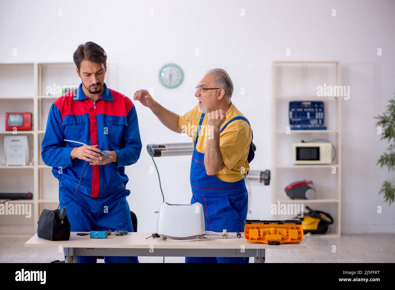 Two repairmen working at workshop Stock Photo - Alamy