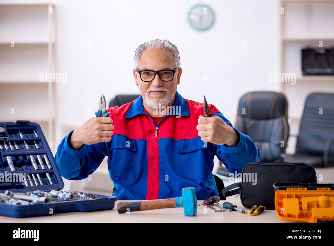 Old repairman working at workshop Stock Photo - Alamy