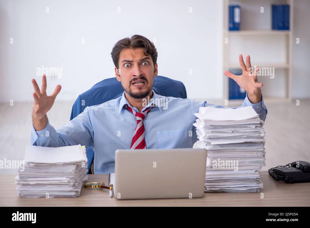 Young businessman employee and too much work in the office Stock Photo ...