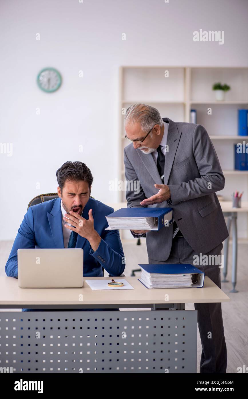 Old boss and young employee working at workplace Stock Photo - Alamy