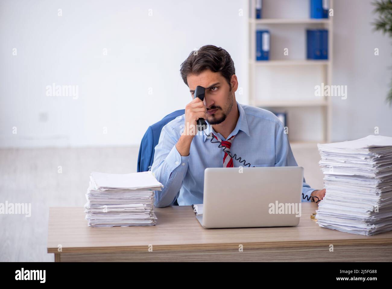 Young businessman employee and too much work in the office Stock Photo ...