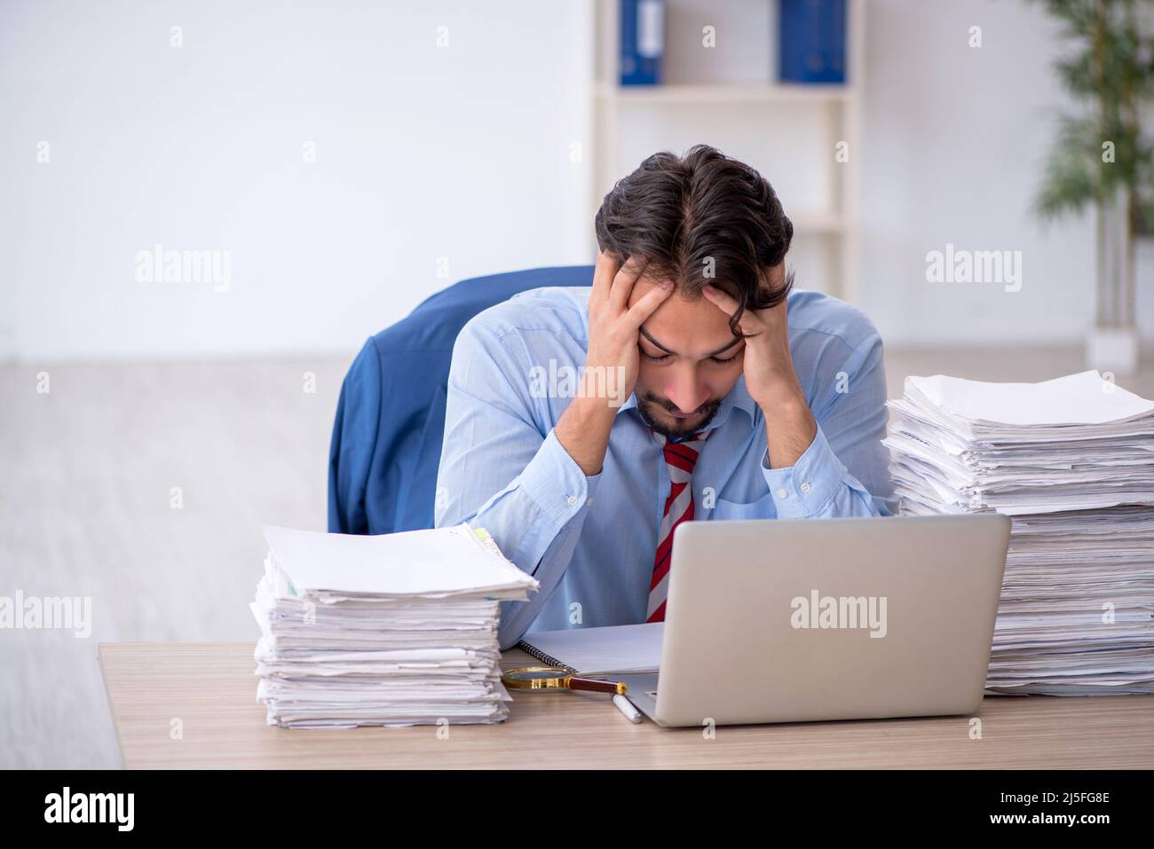Young businessman employee and too much work in the office Stock Photo ...