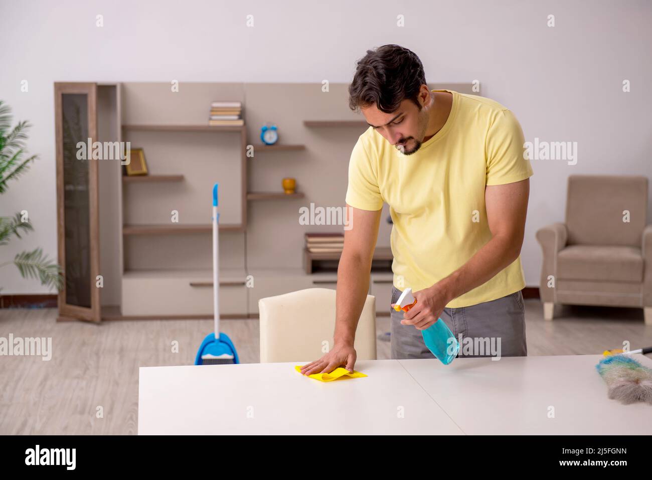 Young man cleaning the house Stock Photo - Alamy