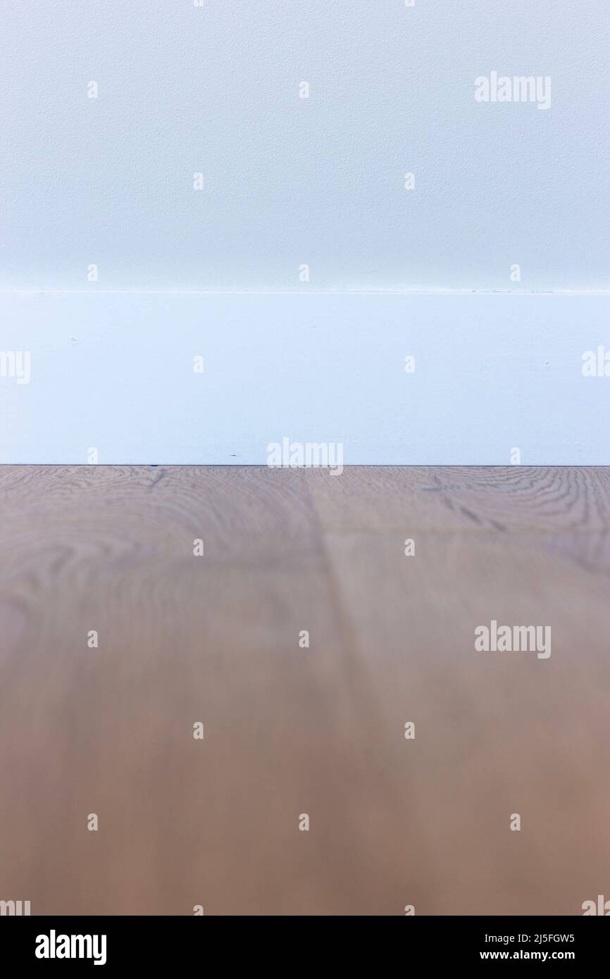 White baseboard, white wall and wood laminate Stock Photo - Alamy