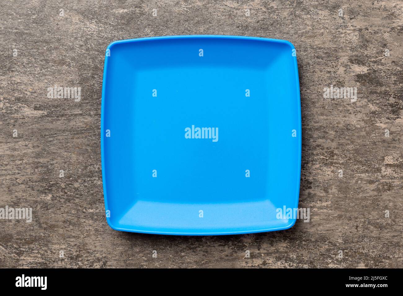 Top view of empty square plate on cement background. Empty space for ...