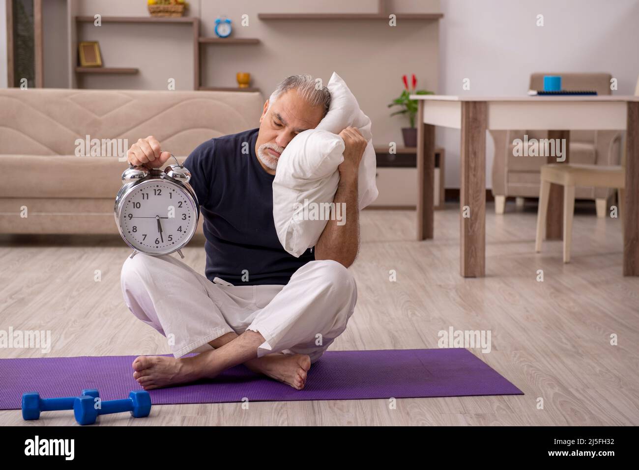 Old man doing sport exercises indoors Stock Photo - Alamy